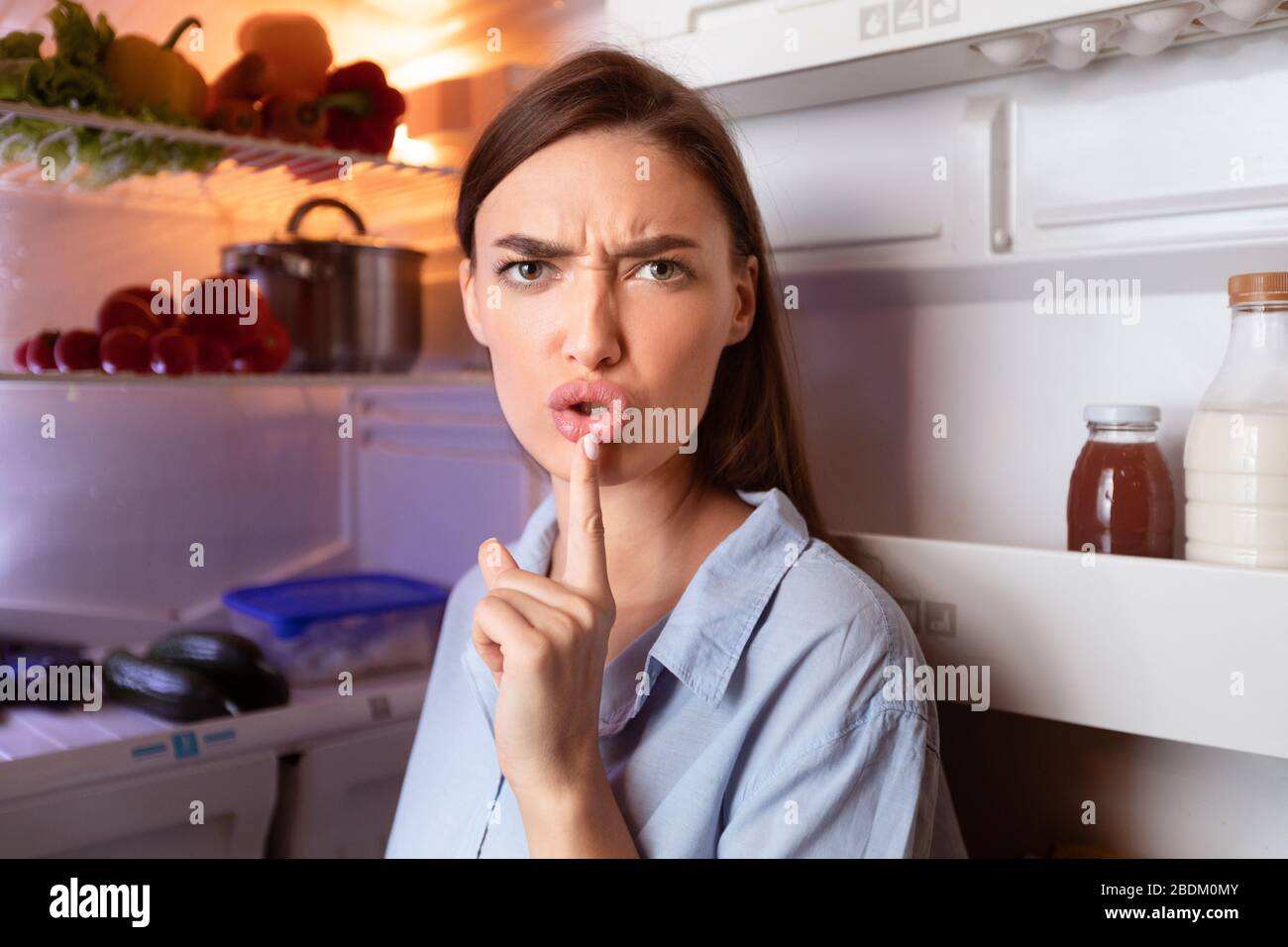 Angry hungry woman opening fridge late, gesturing on camera Stock Photo ...