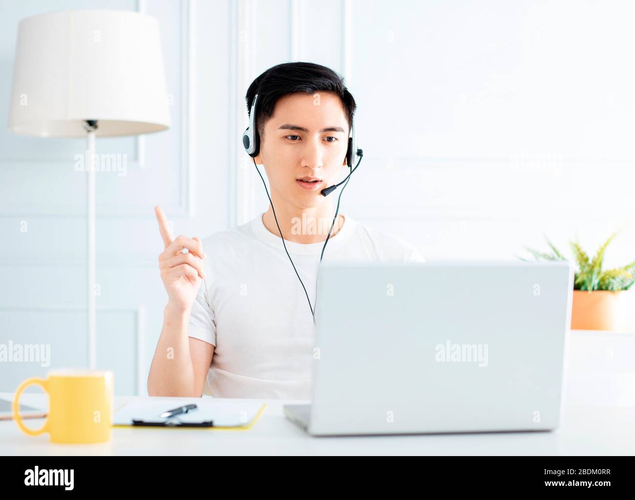 smiling young man working from home with laptop Stock Photo - Alamy