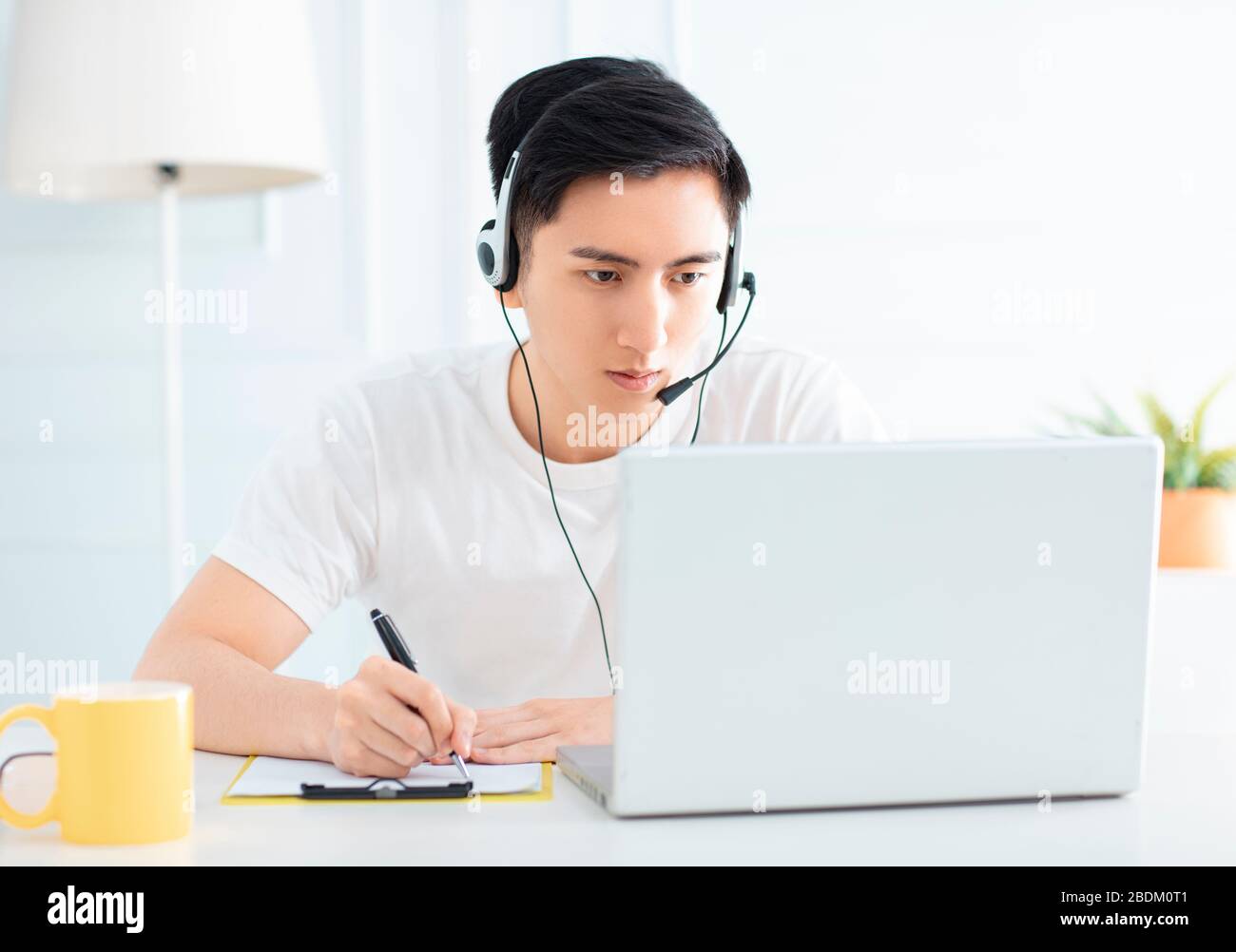 smiling young man working from home with laptop Stock Photo - Alamy