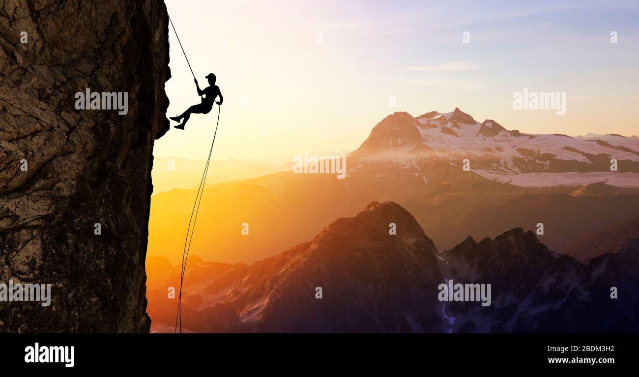 Silhouette Rappelling from Cliff Stock Photo - Alamy