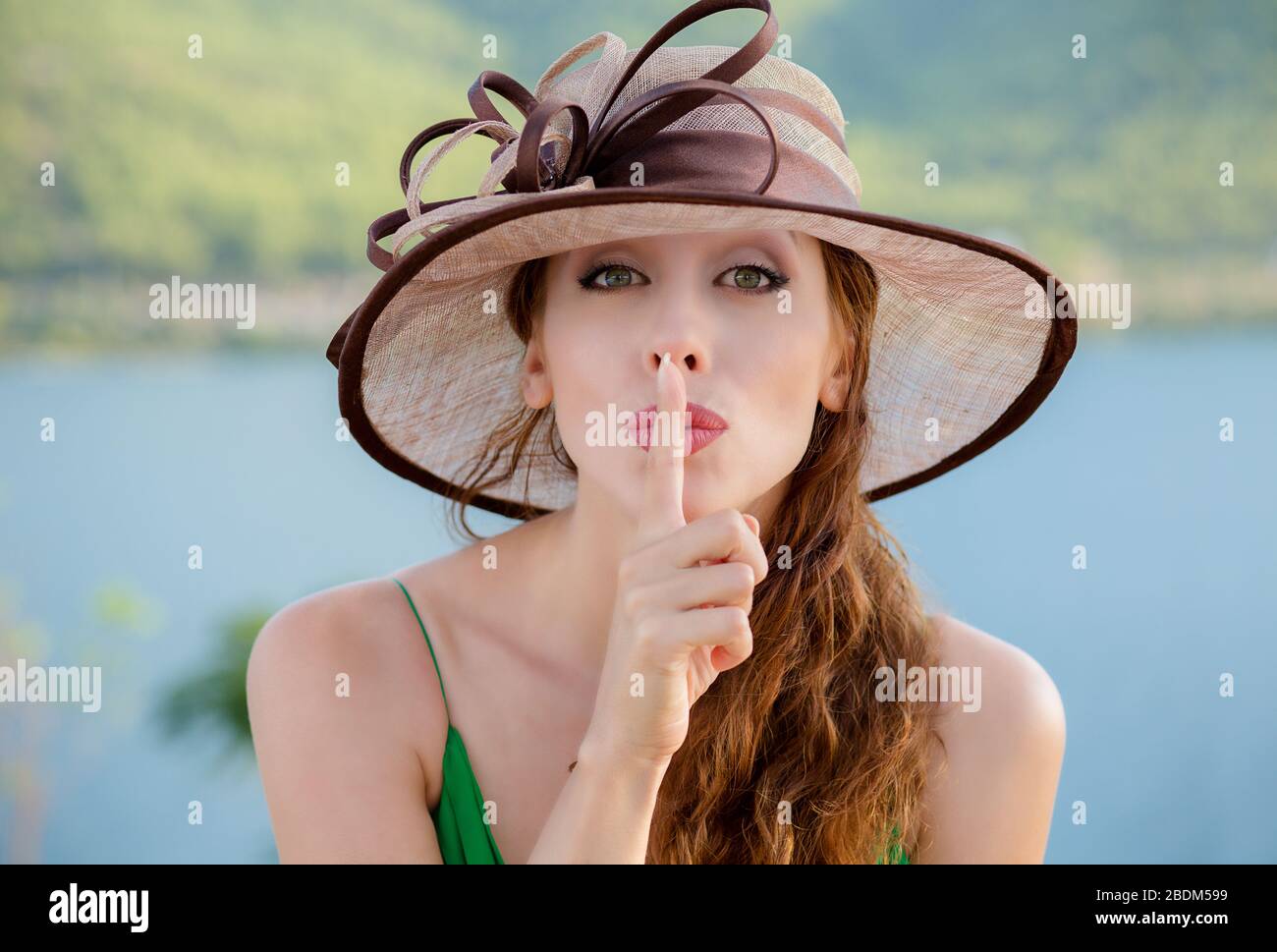 Woman wide eyed asking for silence or secrecy with finger on lips hush ...