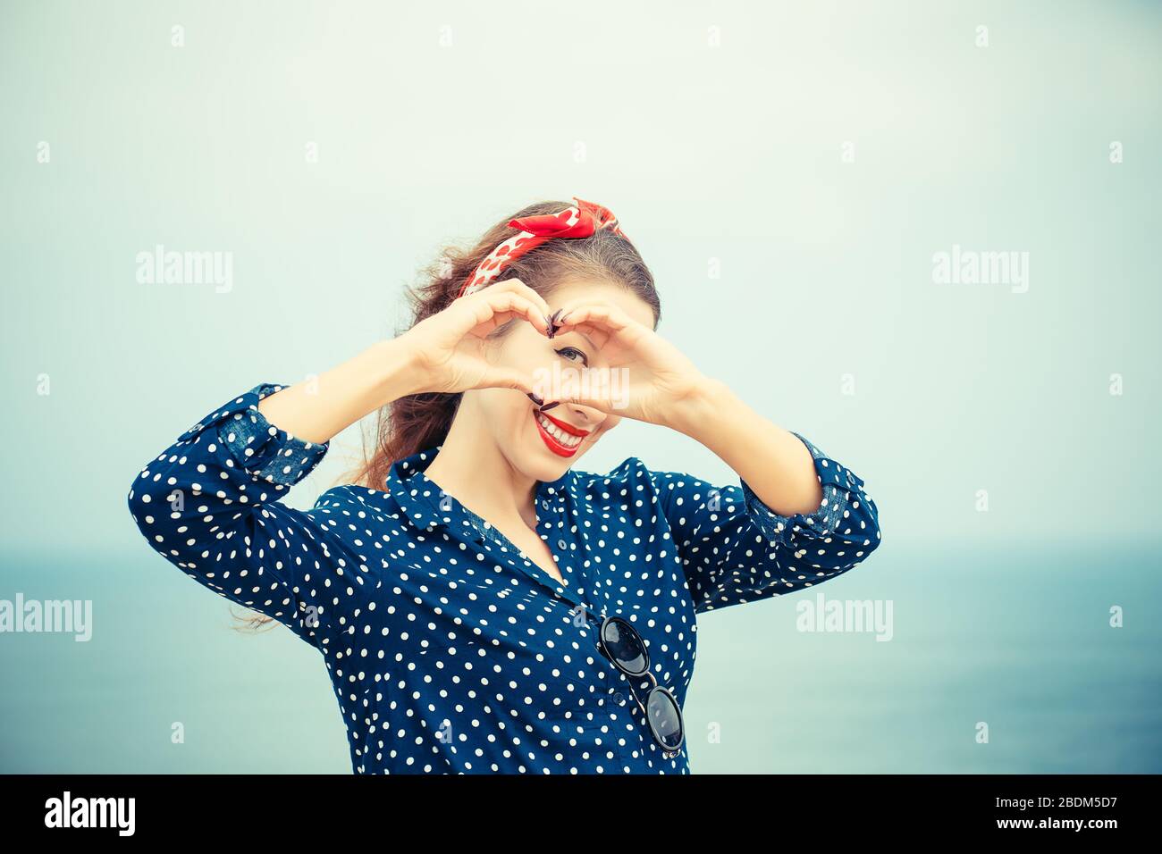 Love. Closeup portrait smiling happy young woman making heart sign ...