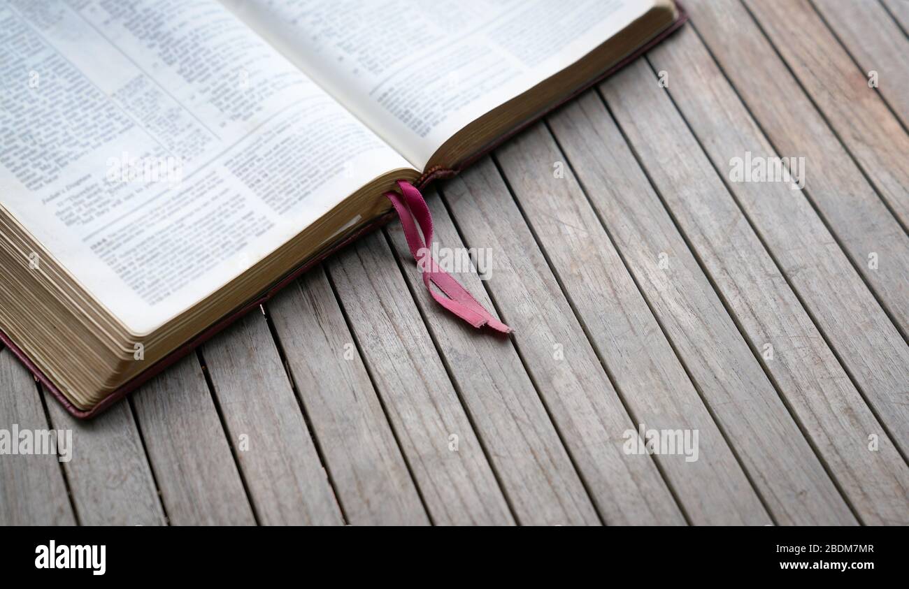 Open bible on wooden table. Soft blur effect with focus on book mark ...