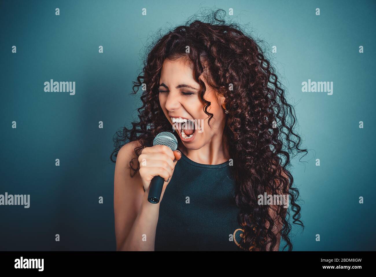 Business woman screaming / talking in microphone. Funny photo of young ...