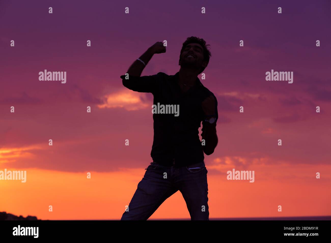 Successful man raising arms on summer sunset. Male arms up celebrating ...