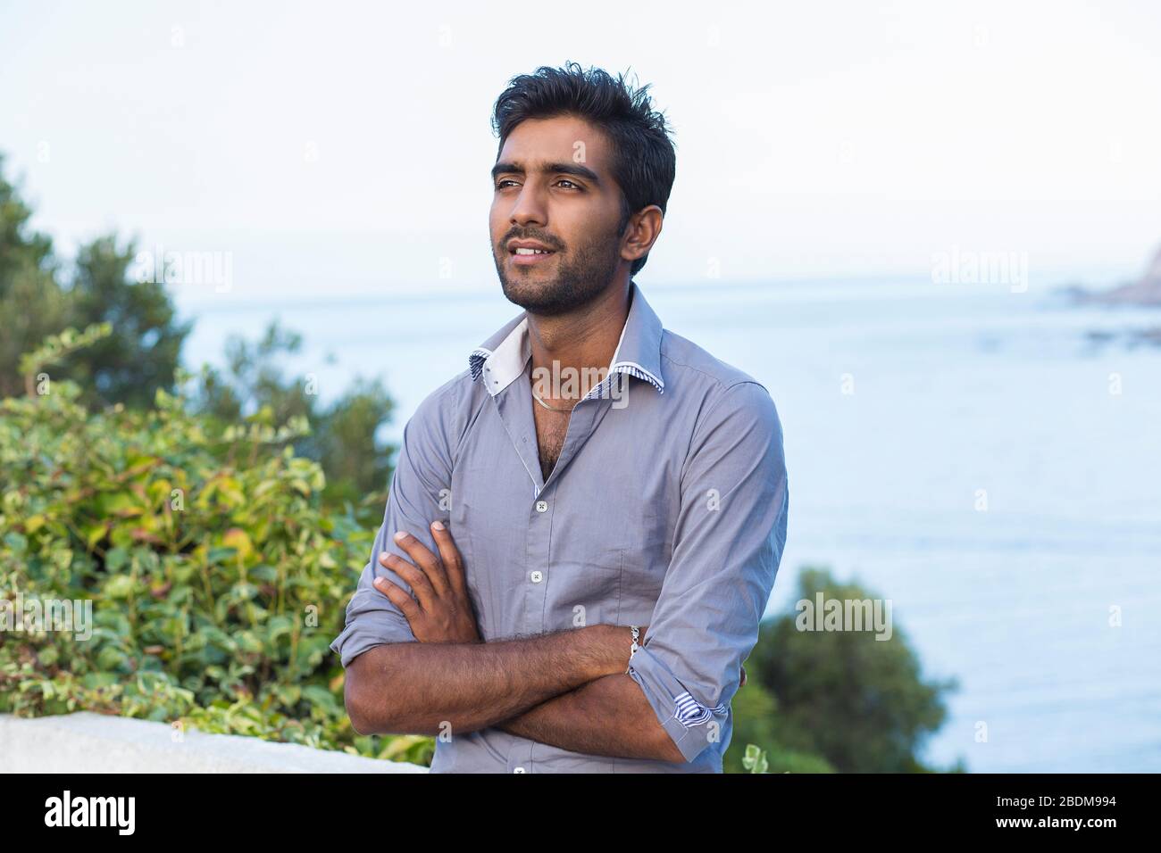 Young Indian business Man thinking isolated outdoors green trees blue ...