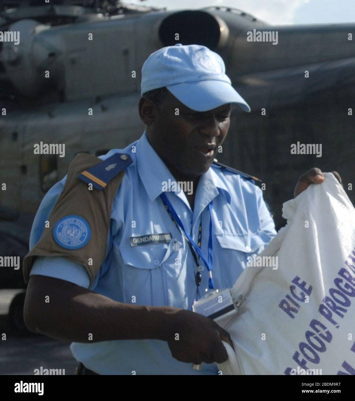 Haitian police with rice bag and UN brassard Stock Photo - Alamy