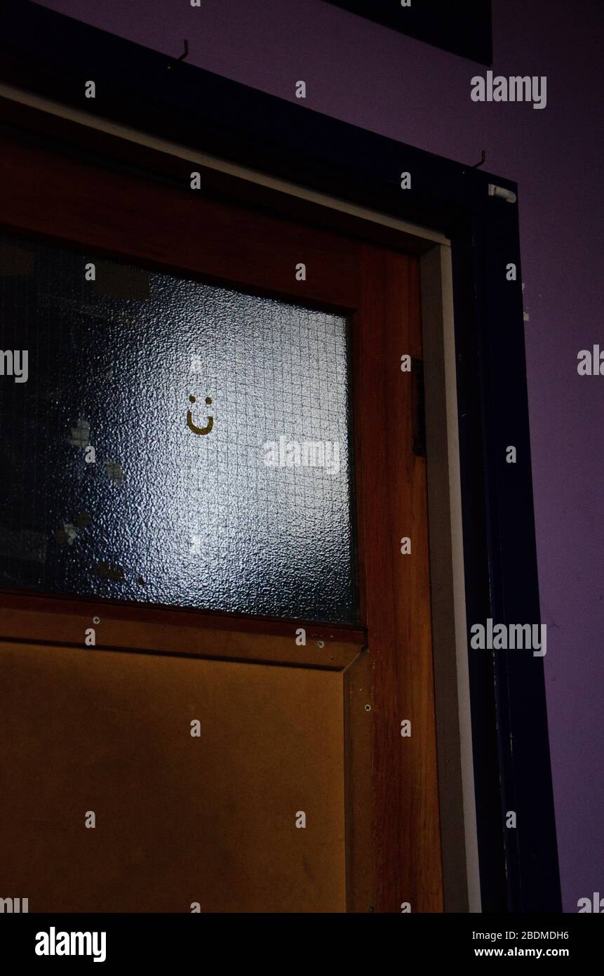 WELLINGTON, NEW ZEALAND - April 4, 2020: Smiley face painted on window ...