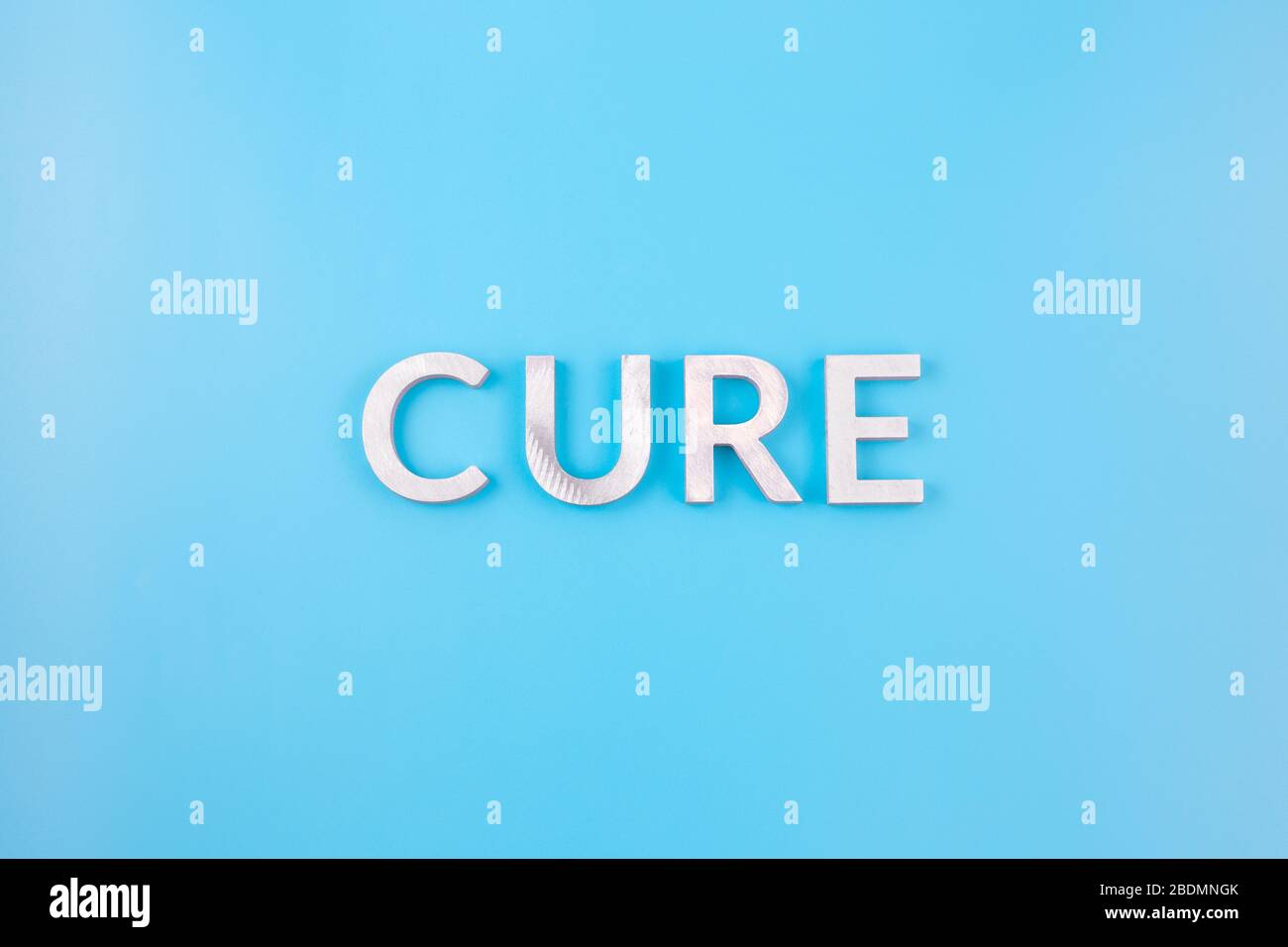 the word cure laid with thick aluminium letters on blue background ...
