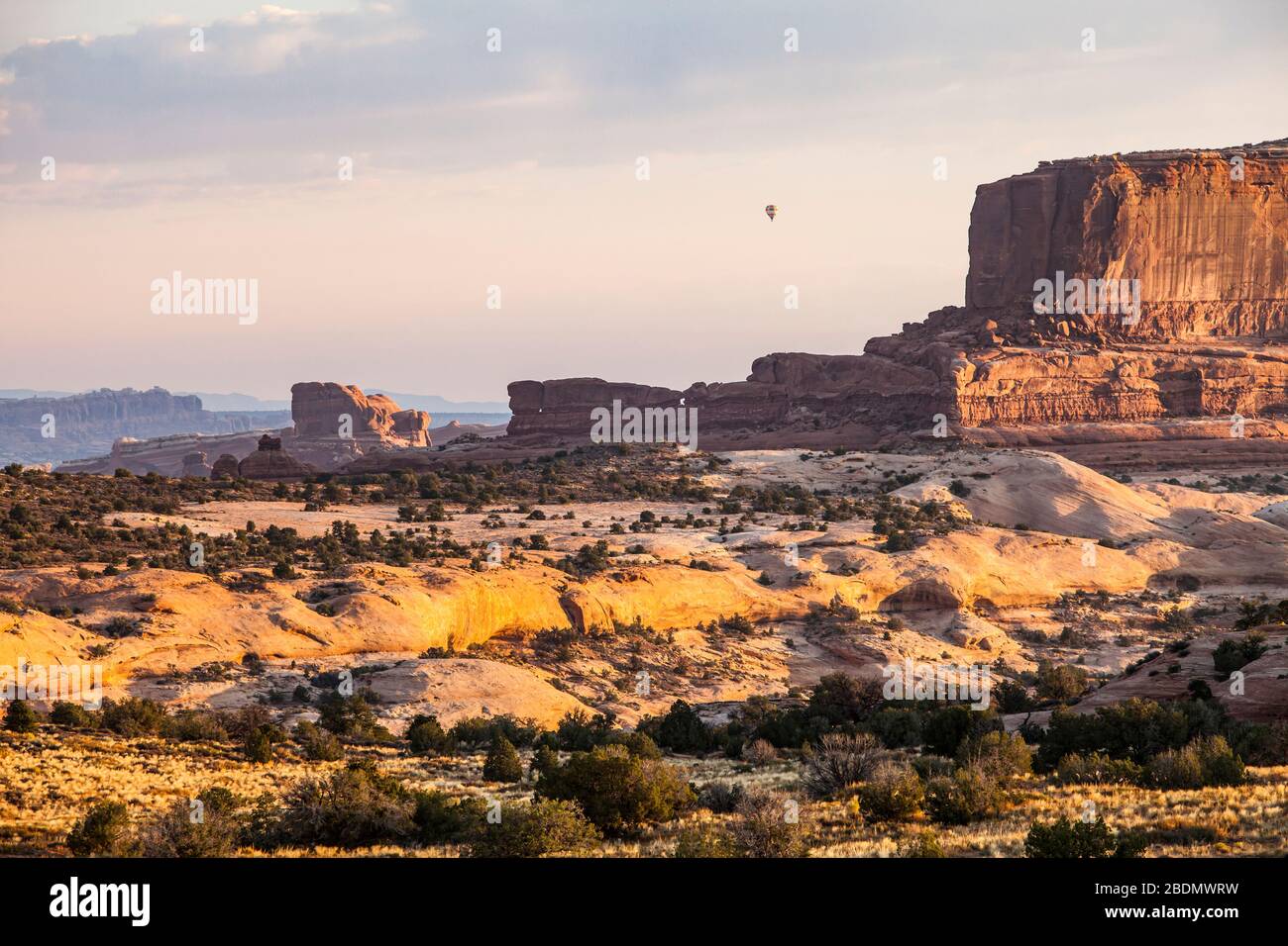 Sunrise and a hot air balloon over the desert landscape Northwest of ...