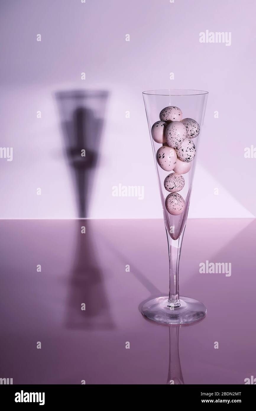 Quail eggs in champagne flute on glossy background. Creative still life ...