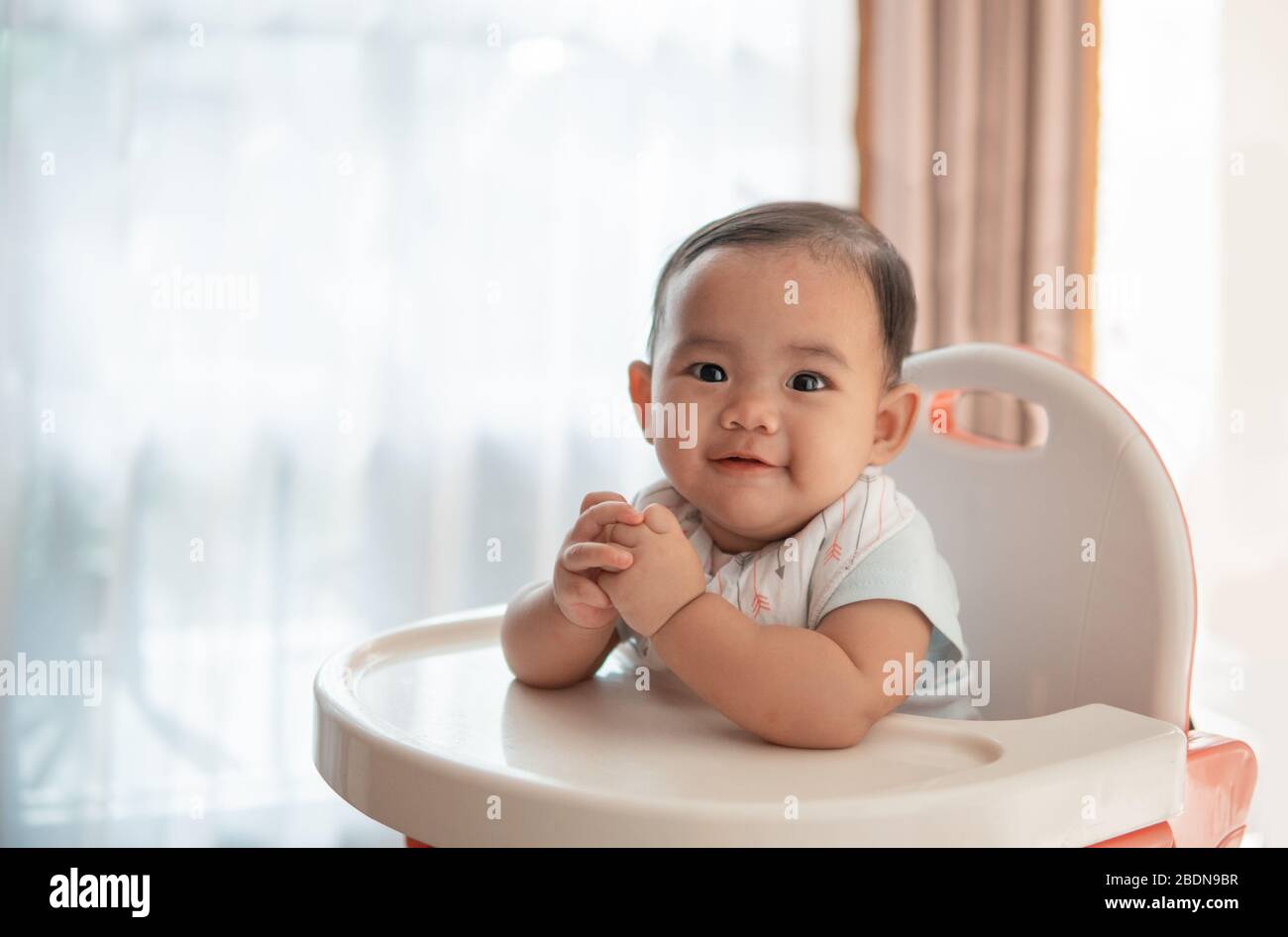 happy asian baby feeding time sitting on highchair Stock Photo - Alamy