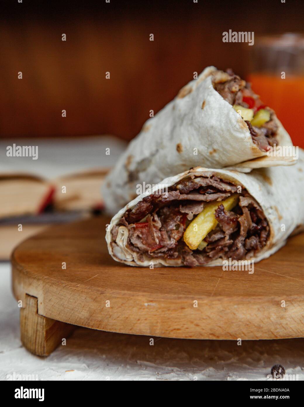 close up of beef doner wrap with flatbread pickled cucumber tomato and ...