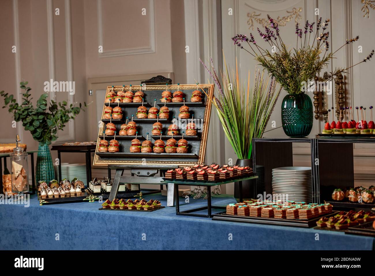 buffet table of mini cakes and burgers Stock Photo - Alamy