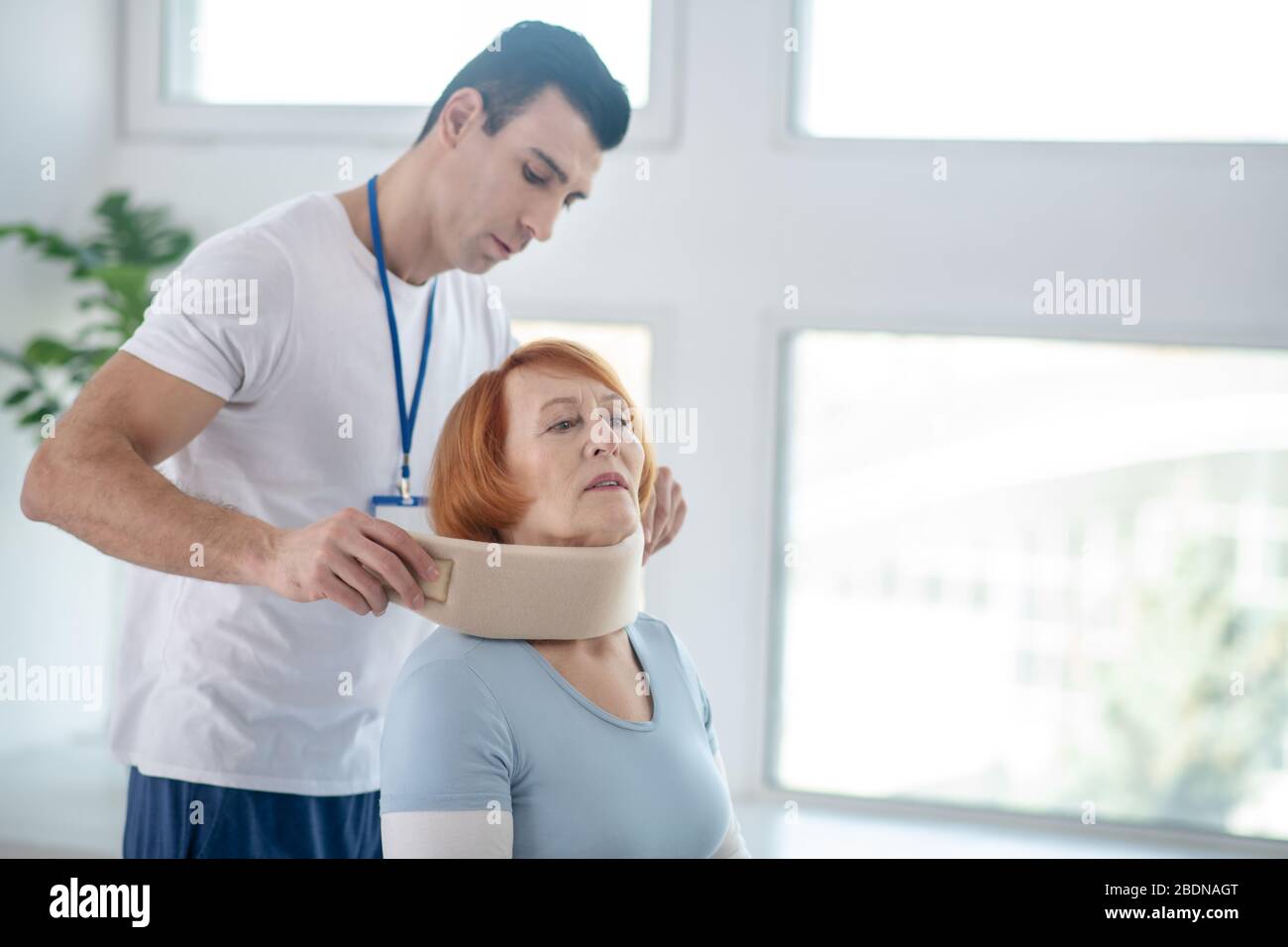 Professional male doctor putting on cervical collar Stock Photo - Alamy