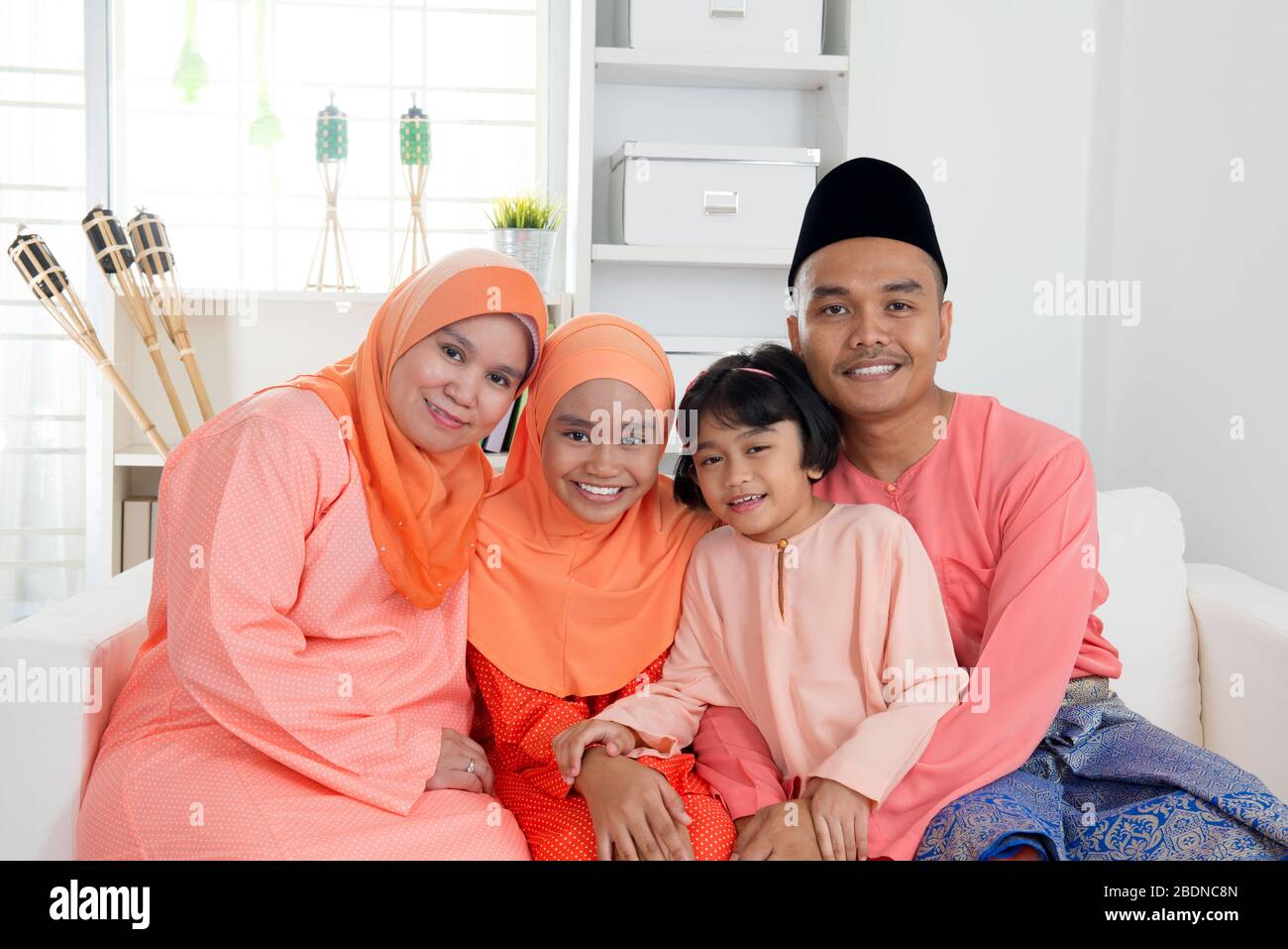 Happy Malay family portrait in traditional clothing during Hari Raya. Malaysian family lifestyle ...