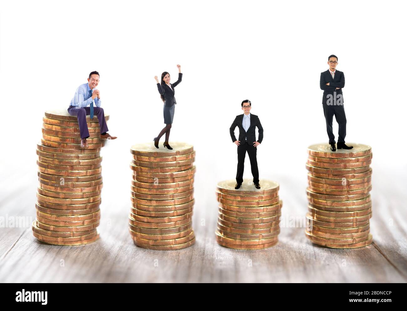 Miniature business people sitting and standing on stack of coins Stock ...