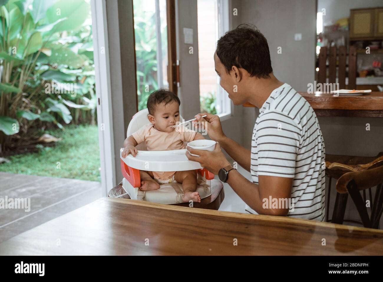 father feeding baby. meal time man taking care for his daughter Stock ...