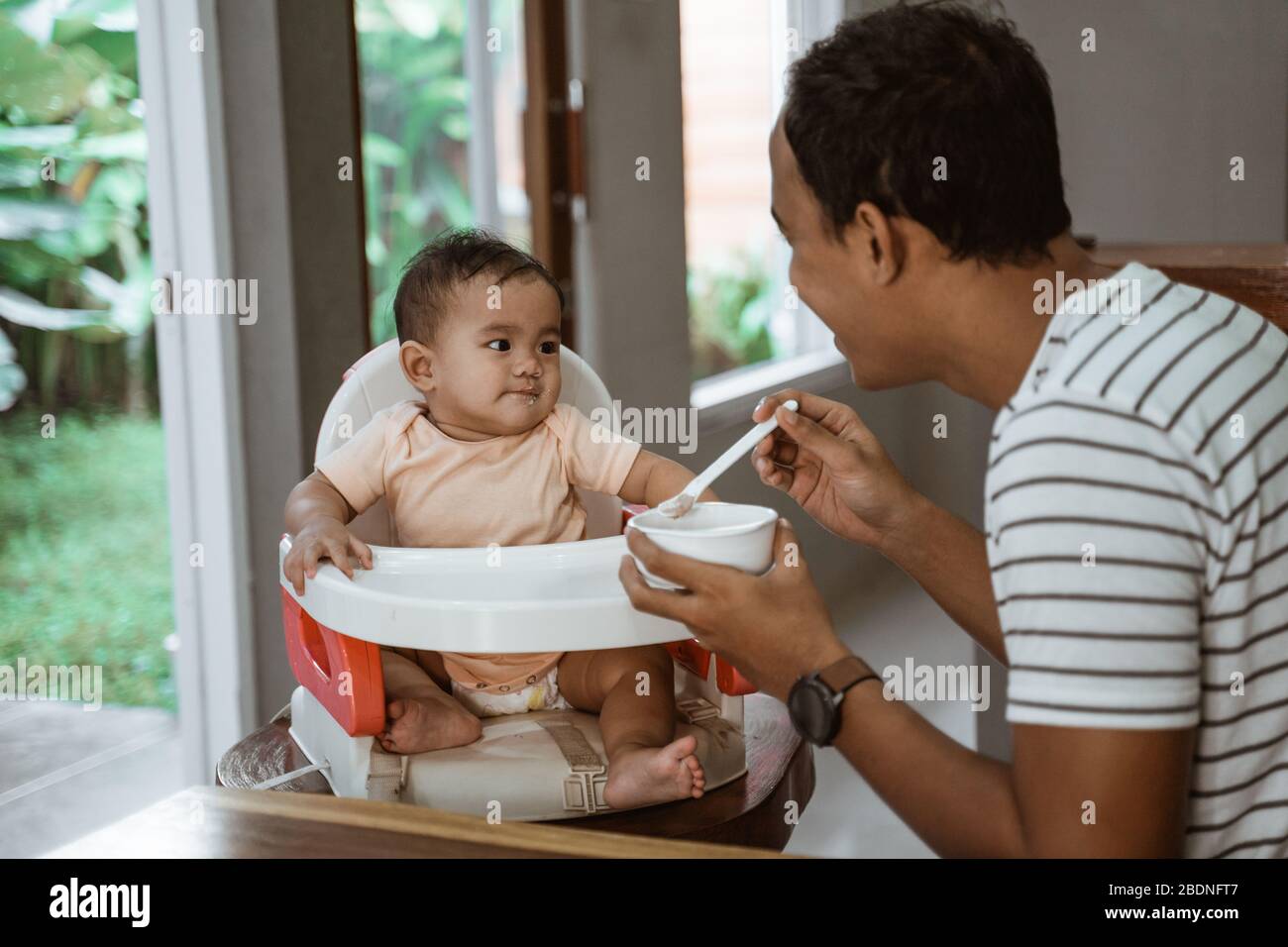 father feeding baby. meal time man taking care for his daughter Stock ...