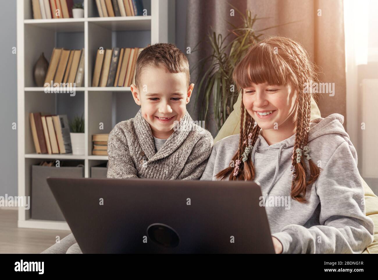 Two happy children using laptop Stock Photo - Alamy