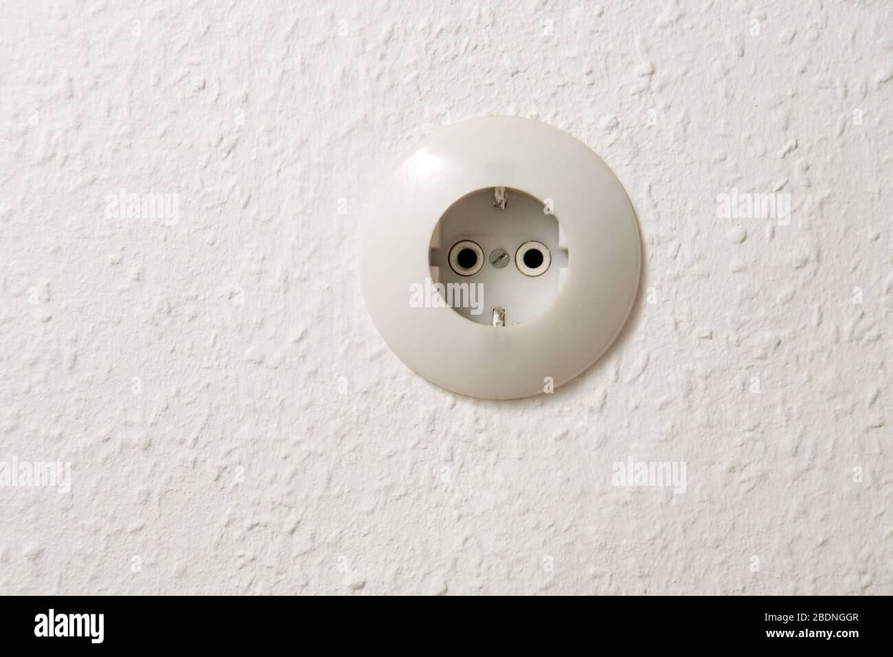 A round wall socket with white wallpaper Stock Photo - Alamy