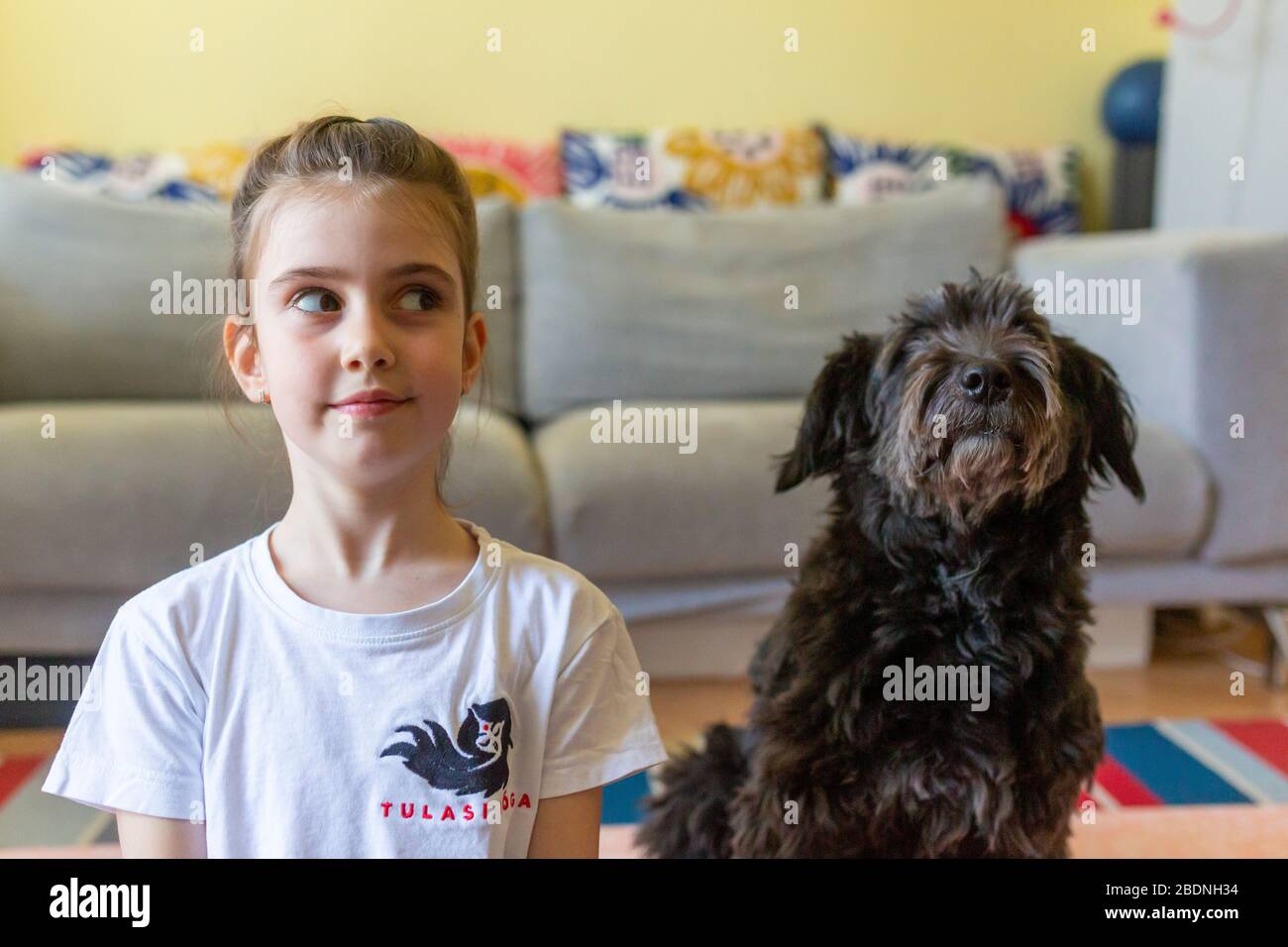 Beautiful, cute little girl with her dog at home Stock Photo - Alamy