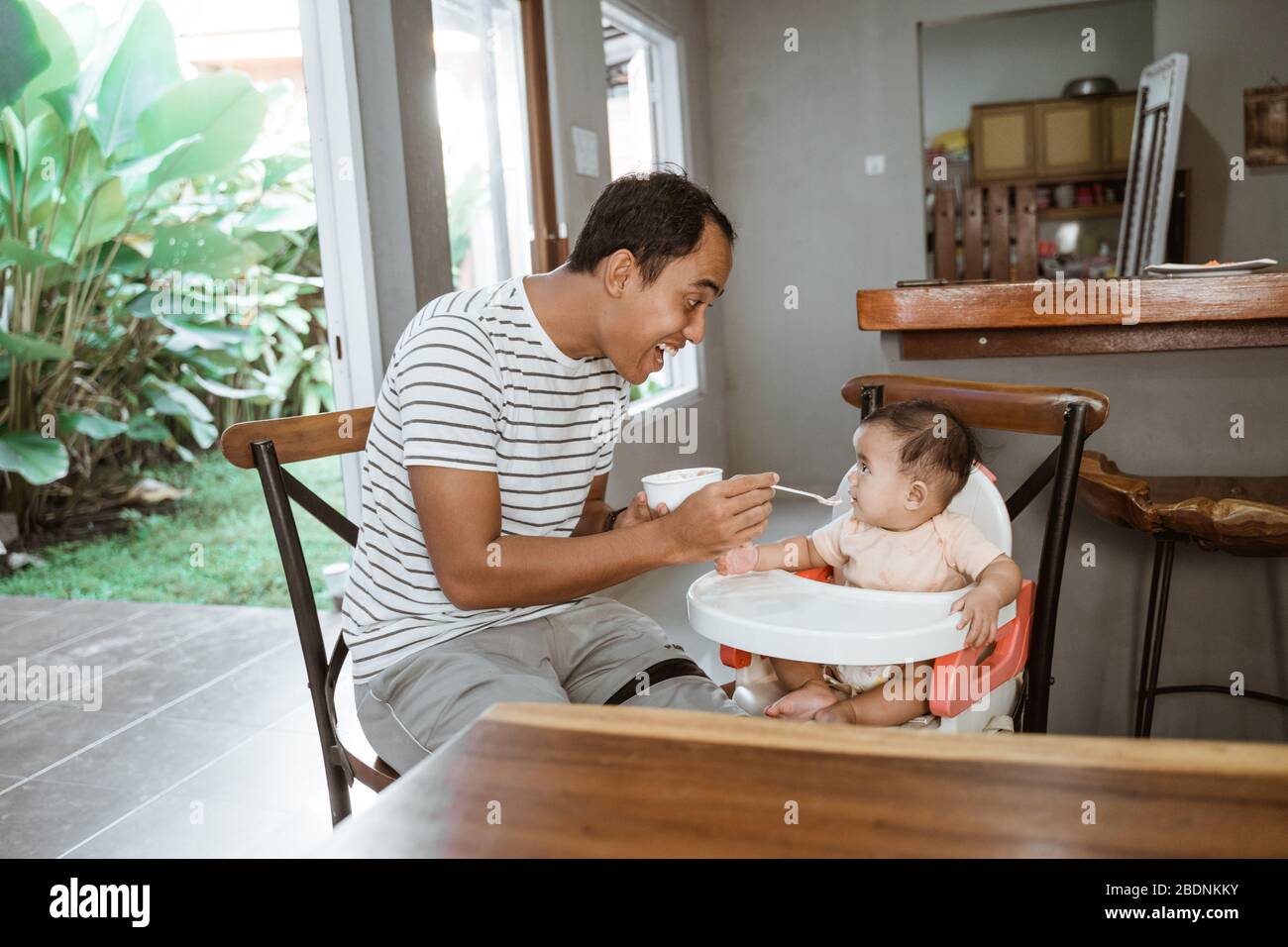 Father feeding baby son highchair hi-res stock photography and images ...