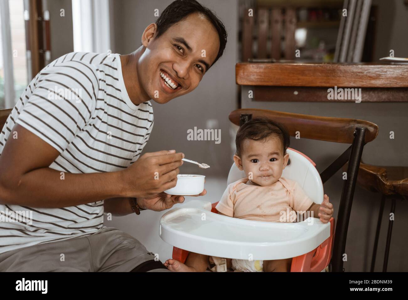 Father feeding baby son highchair hi-res stock photography and images ...