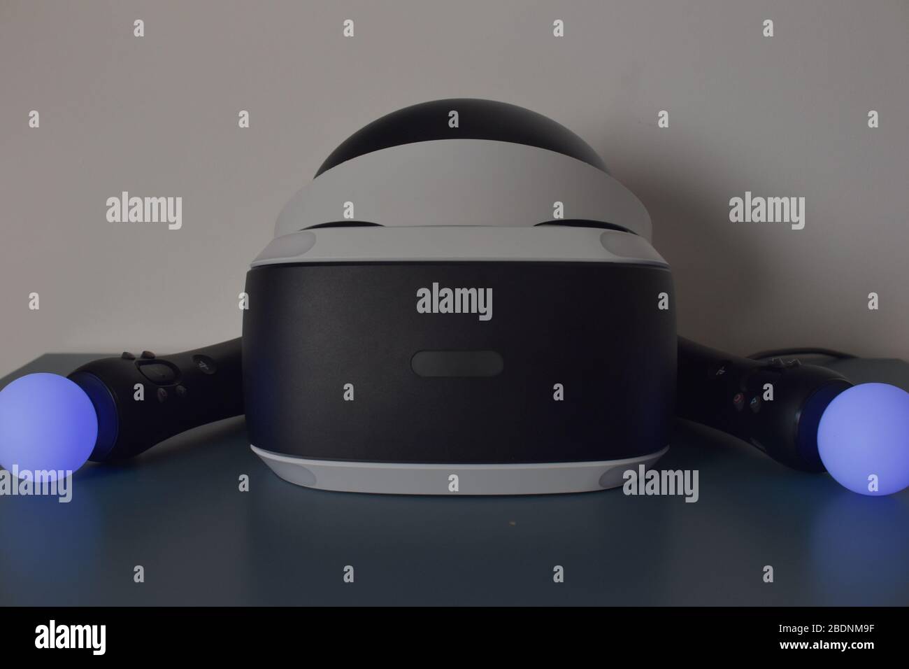 front of psvr with a blue move controller on each side on blue table ...