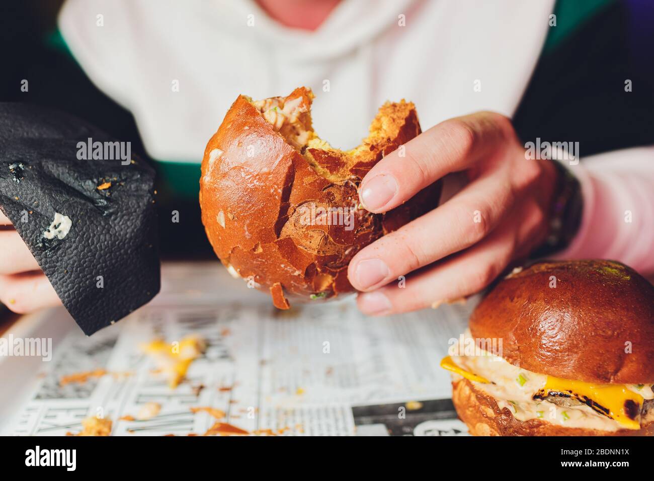 A bitten fresh burger in the hands of a man Stock Photo - Alamy