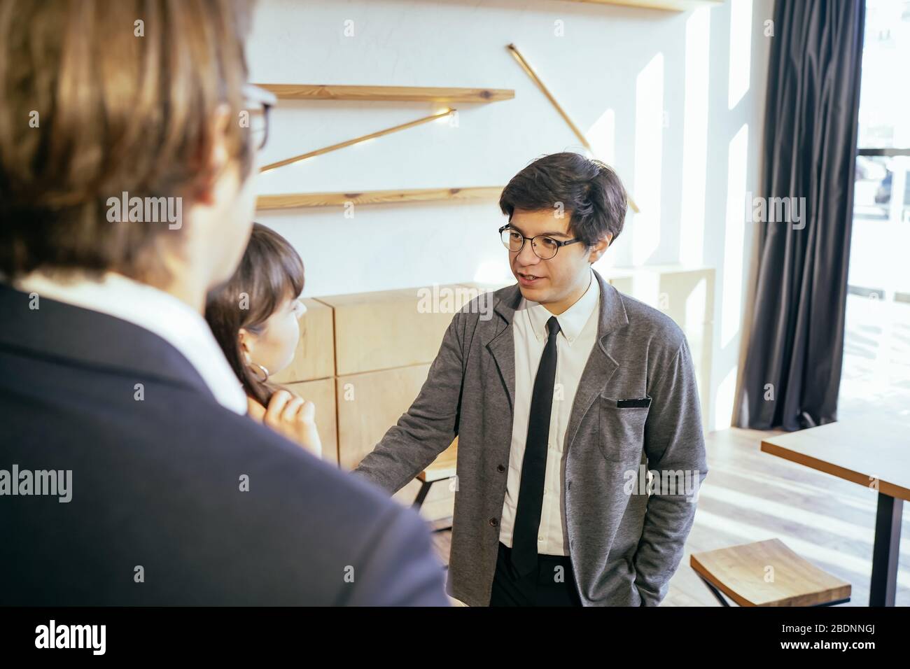 Group of business people in a meeting standing grouped in a office ...