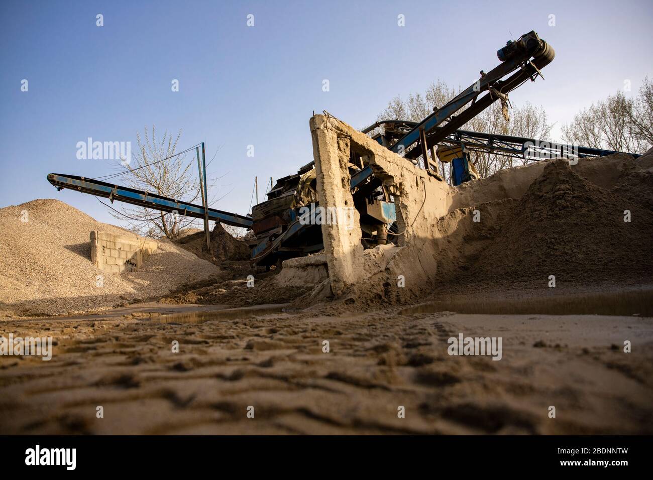 Machine sorting sand and gravel. Excavator and conveyer at the quarry ...