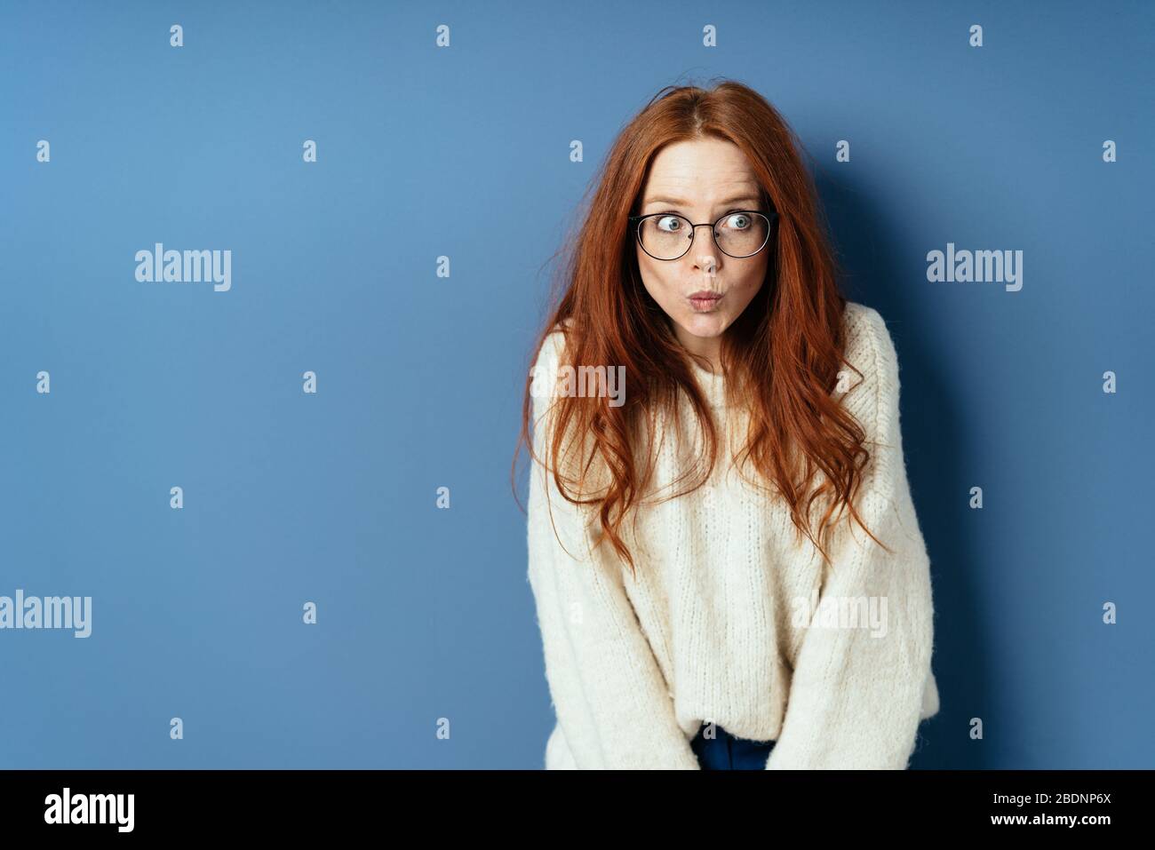 Apprehensive young woman staring to the side with wide eyes and a ...