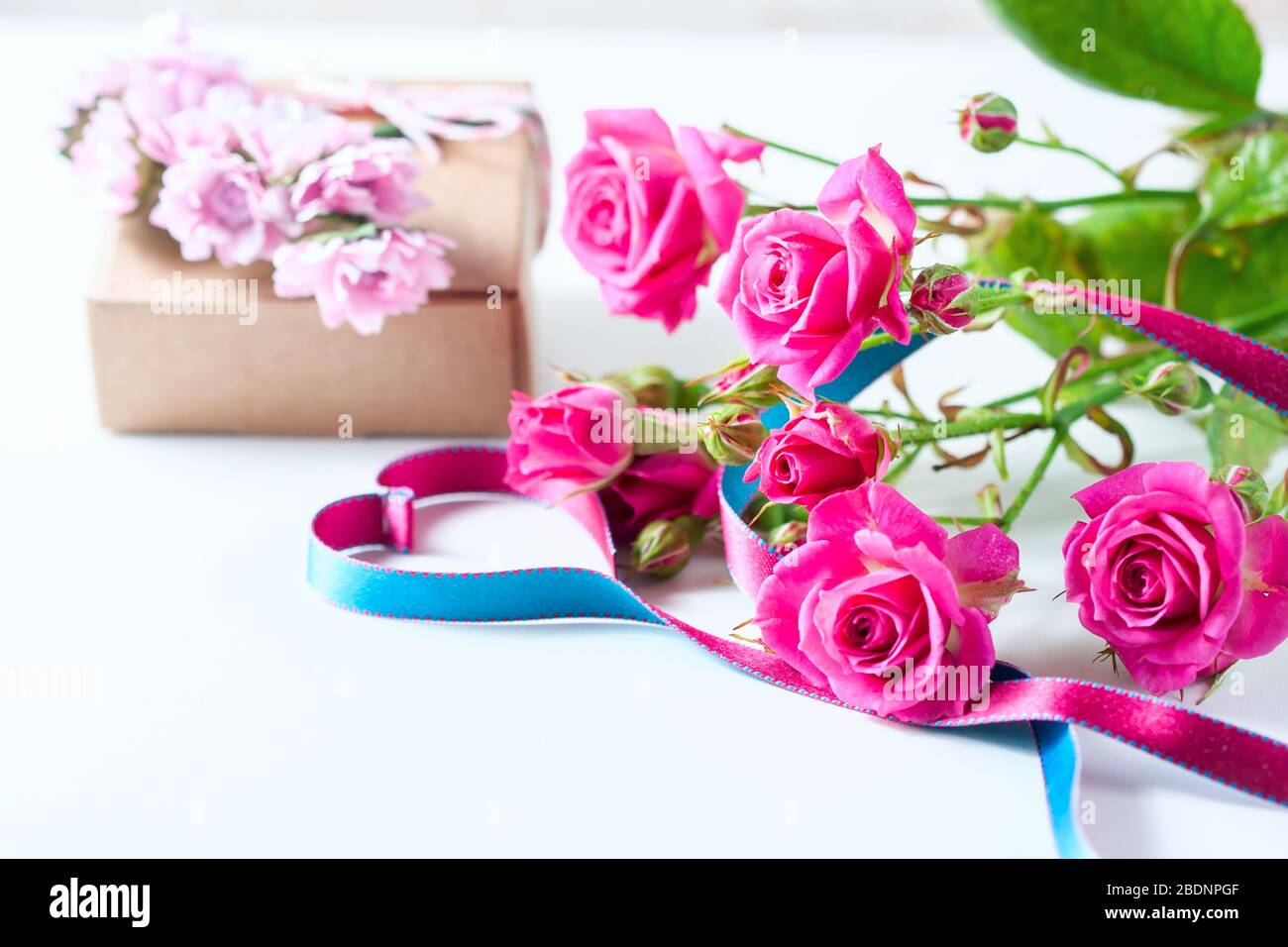 Kraft box and pink roses on white table, concept of Valentine's Day ...