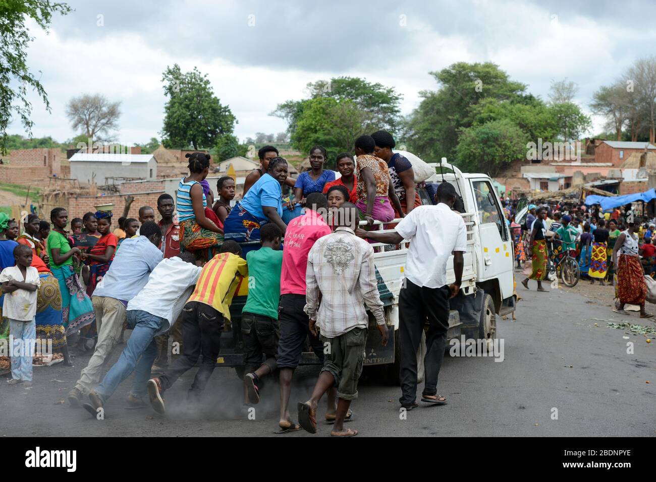 Zambia, Sinazongwe, rural market in village, men push a breakdown mini ...
