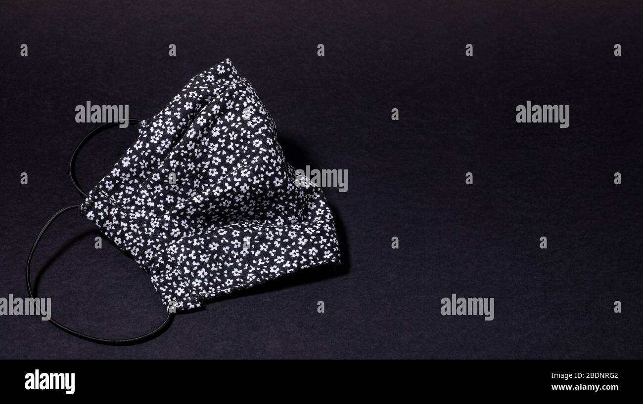 Folded in half textile handmade medical mask with black and white ...