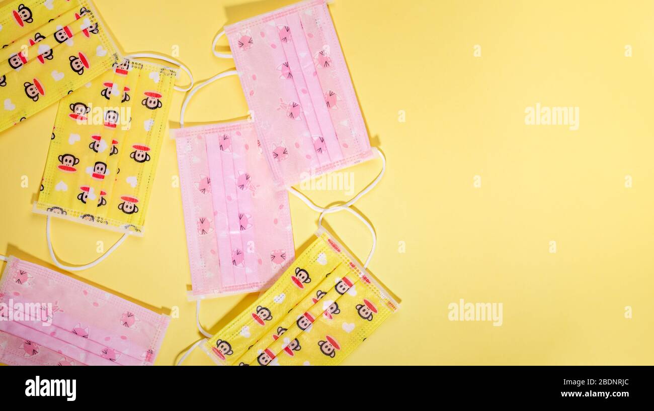 Set of childrens pink and yellow medical masks on yellow. Masks - means ...