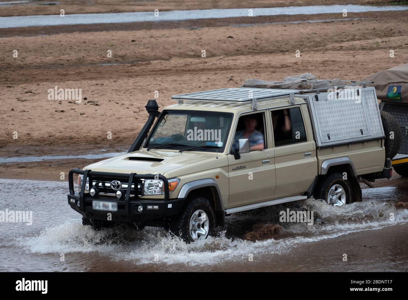 A vehicle towing a trailer crossing a river in africa Stock Photo - Alamy