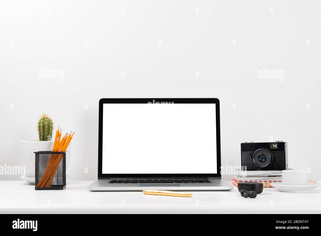 Workplace with laptop computer white blank screen on work table front ...