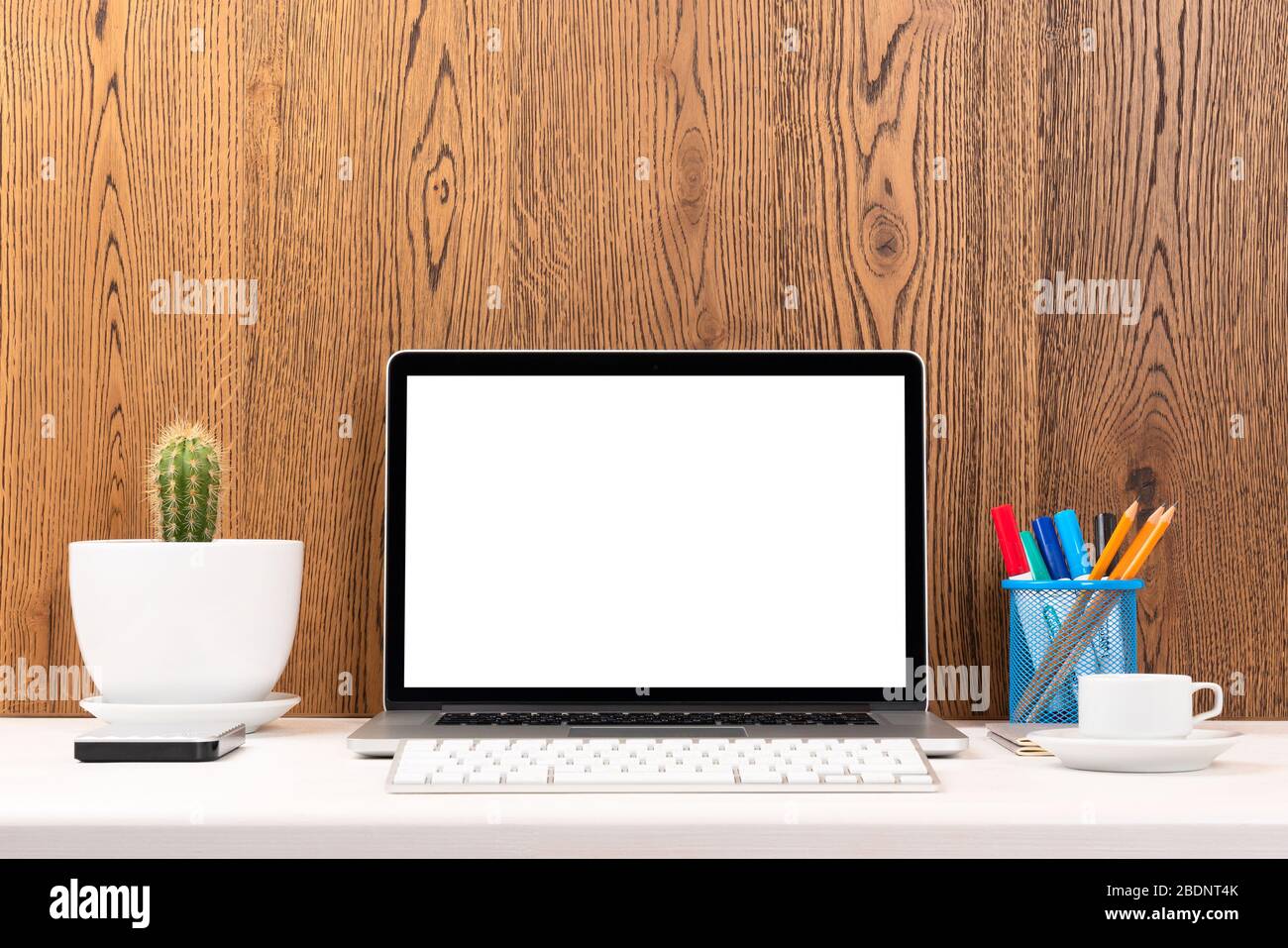 Workplace with laptop computer white blank screen on work table front ...