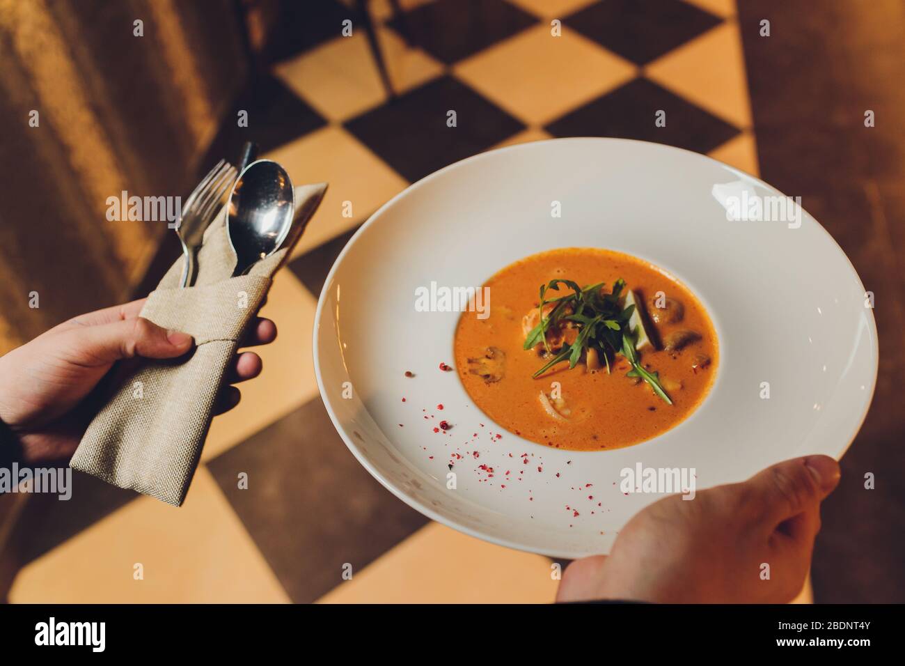 Waiter holding food on hand for serve with chef cooking in the ...