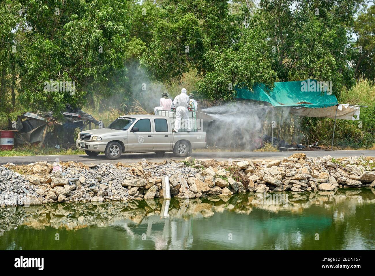 Men in white protective suits spraying a liquid Stock Photo - Alamy