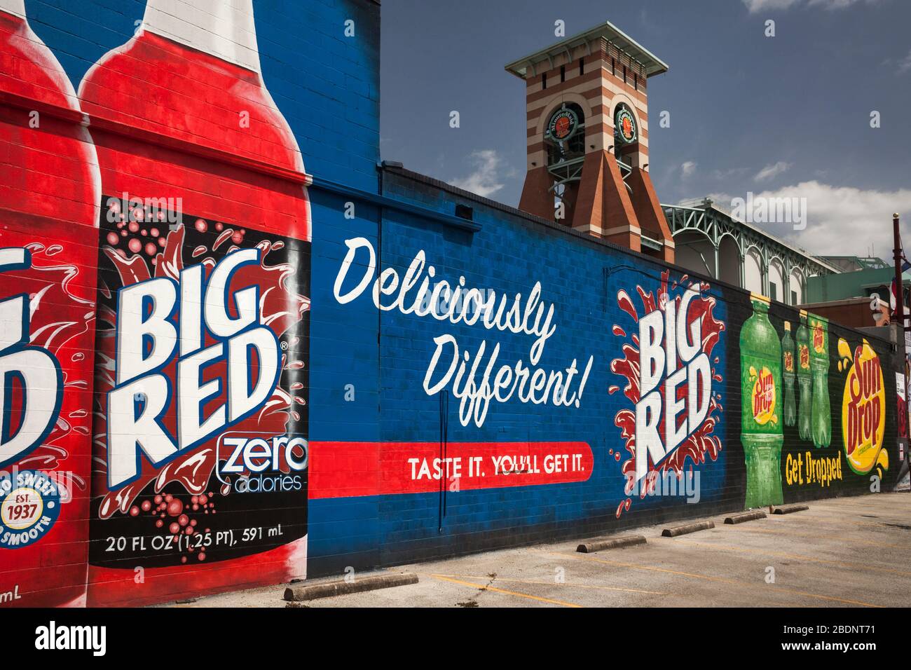 Slanted view of a soft drink brand mural on a public parking wall ...