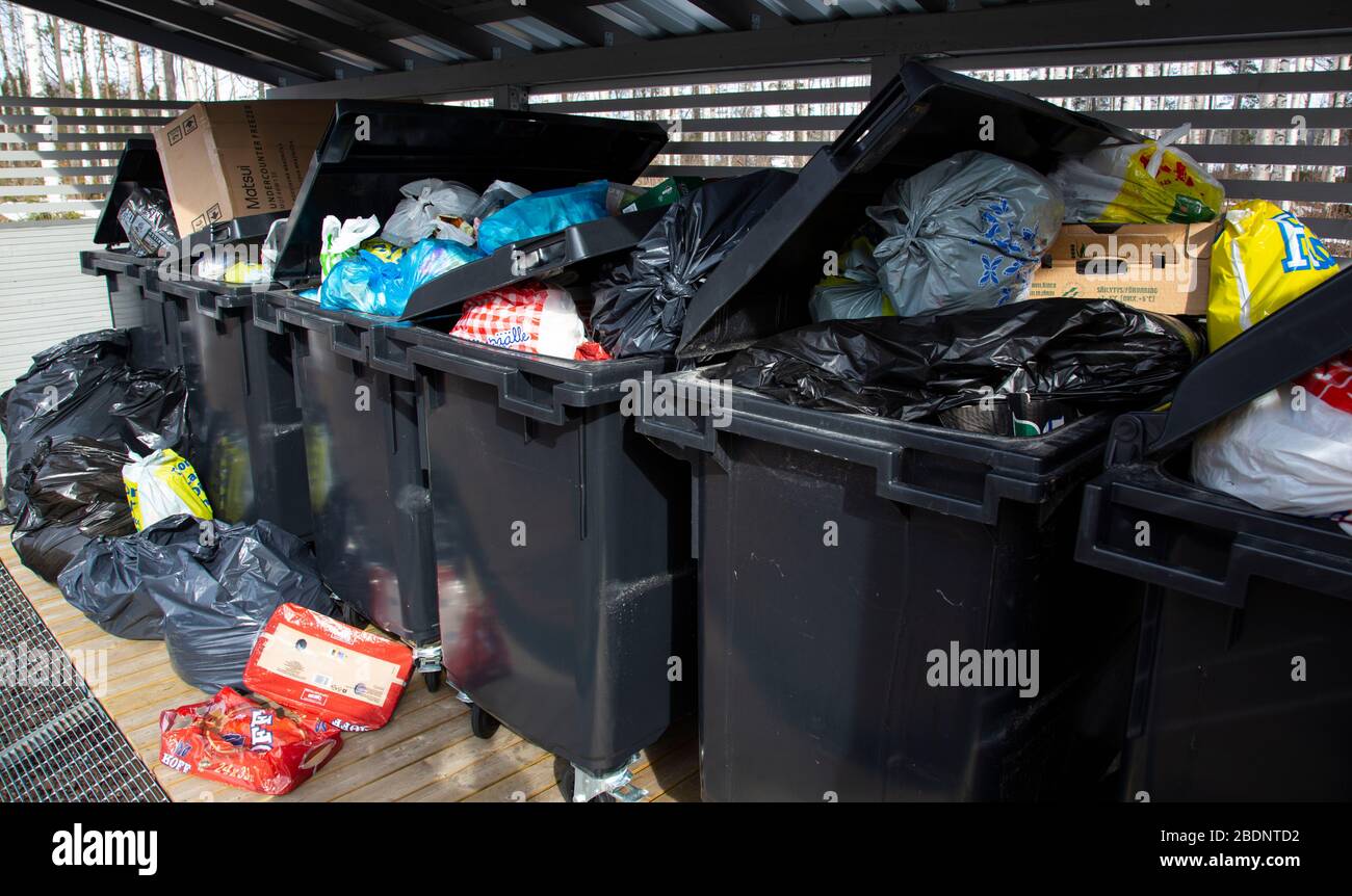 Overfilled 400 litre household trash bins at common waste collection ...