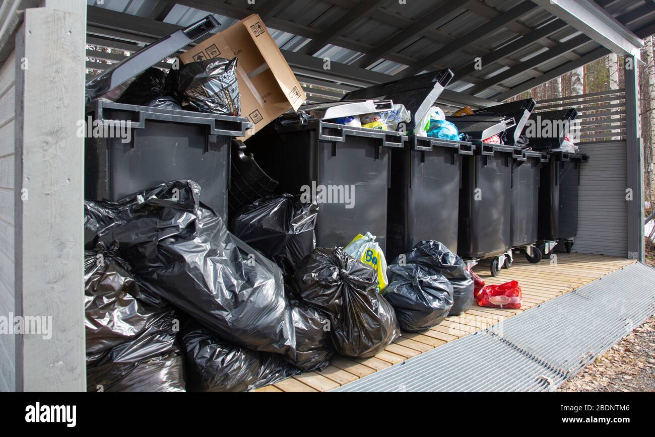 Overfilled 400 litre household trash bins at common waste collection ...
