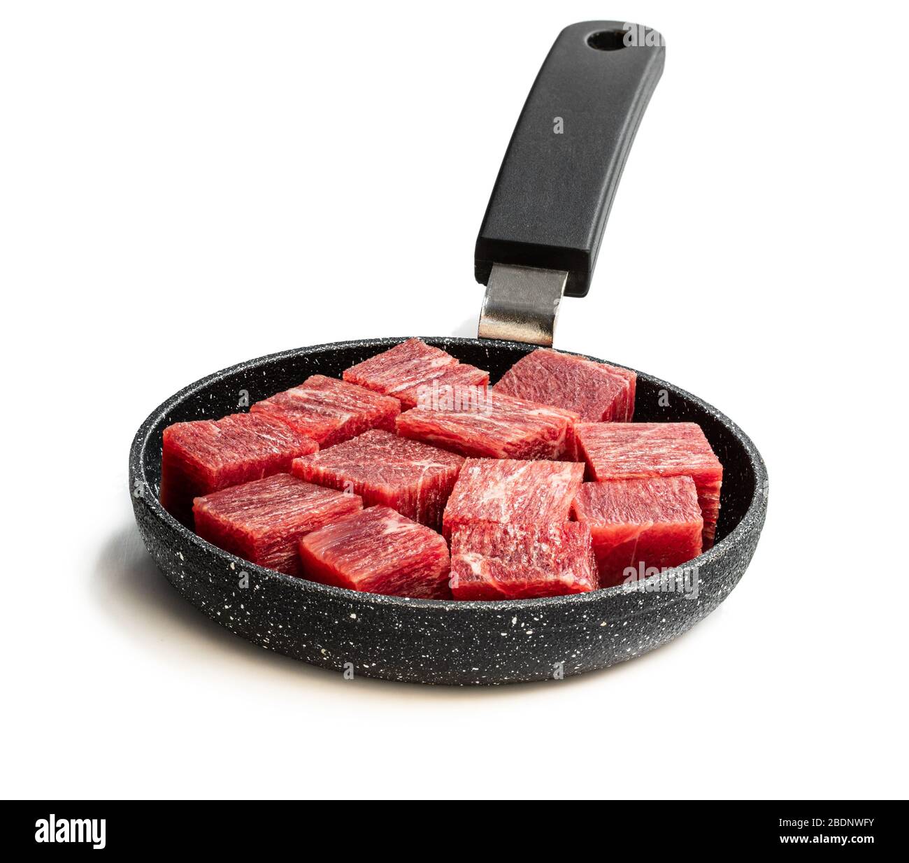 Cubes of raw beef meat on small frying pan isolated on white Stock ...