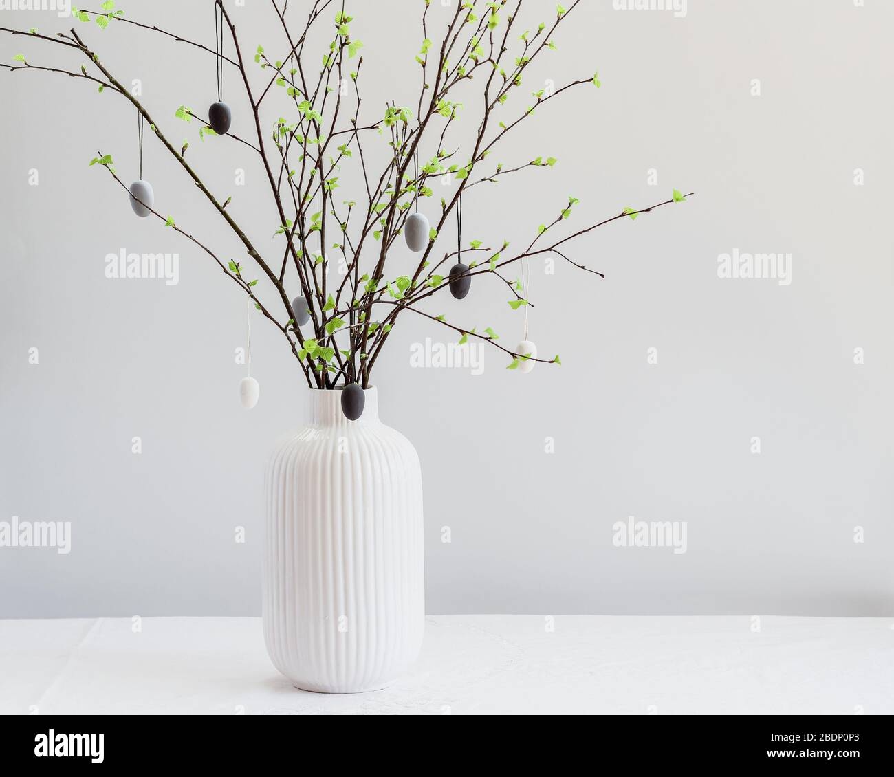 Easter tree on a white table. Birch tree branches decorated with white ...