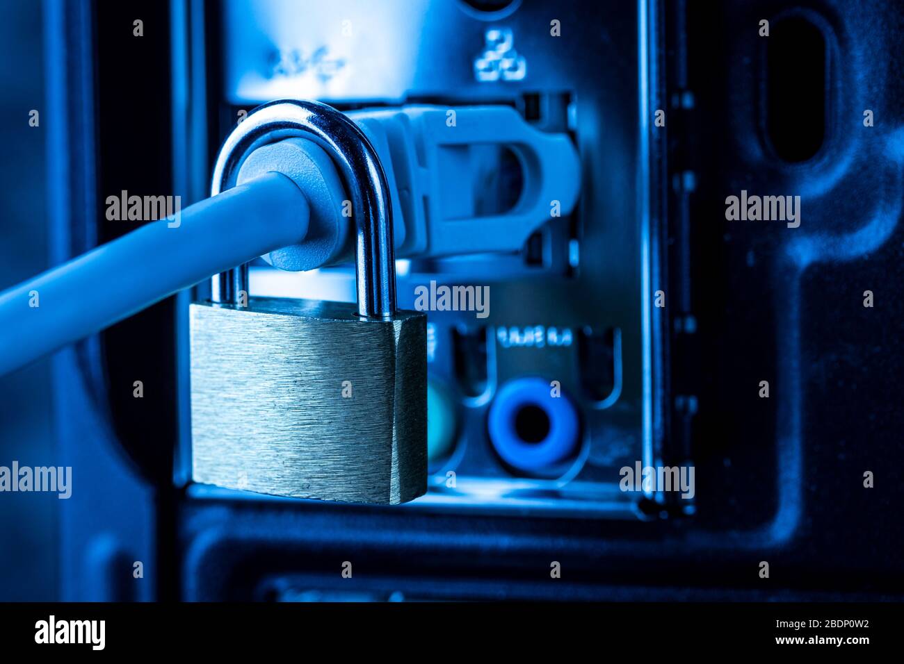Closed lock hanging on a network cable plugged into a computer. The ...
