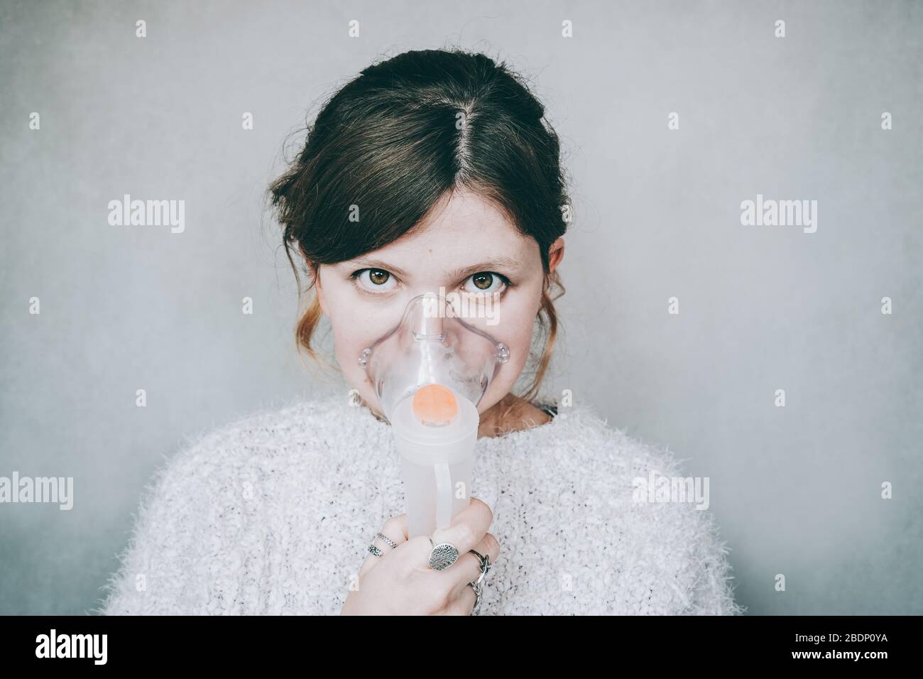 Young woman using a breathing mask Stock Photo - Alamy
