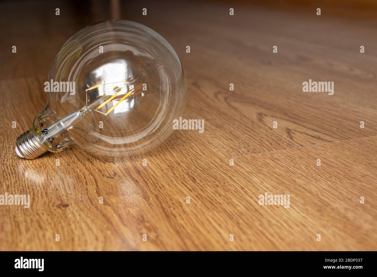 Big light bulb on wooden floor Stock Photo - Alamy
